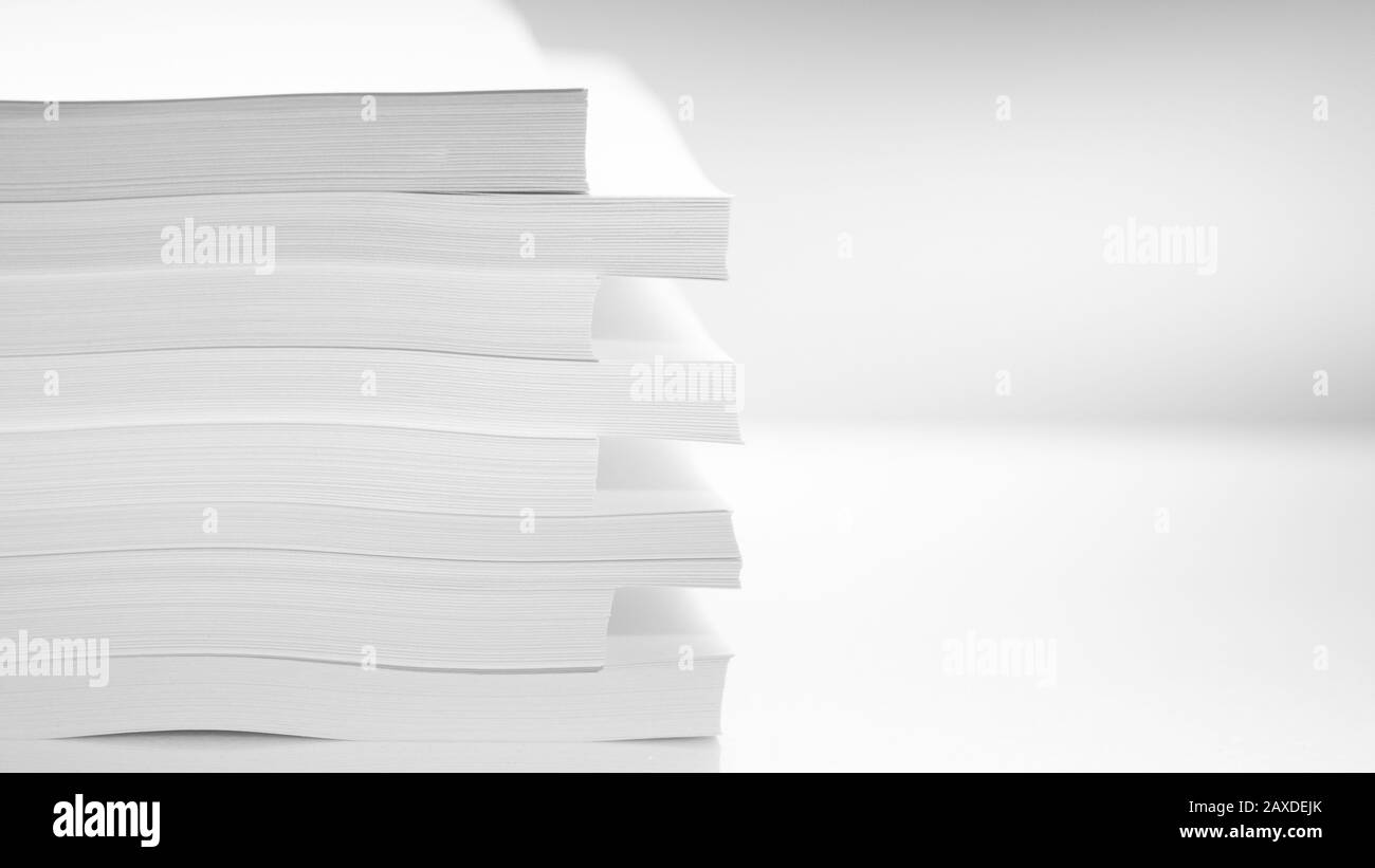 Several stacks of white paper on a white background Stock Photo - Alamy