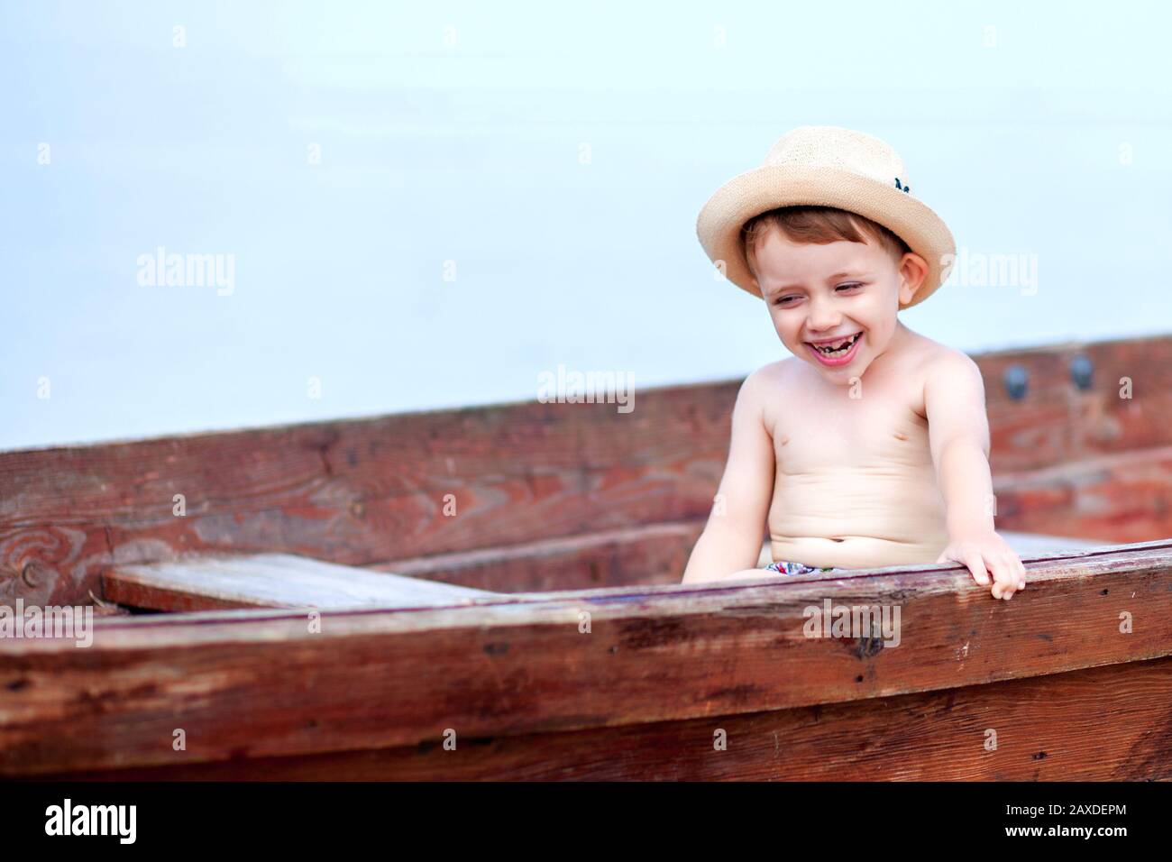 Little boy is resting in a boat on the lake Stock Photo - Alamy
