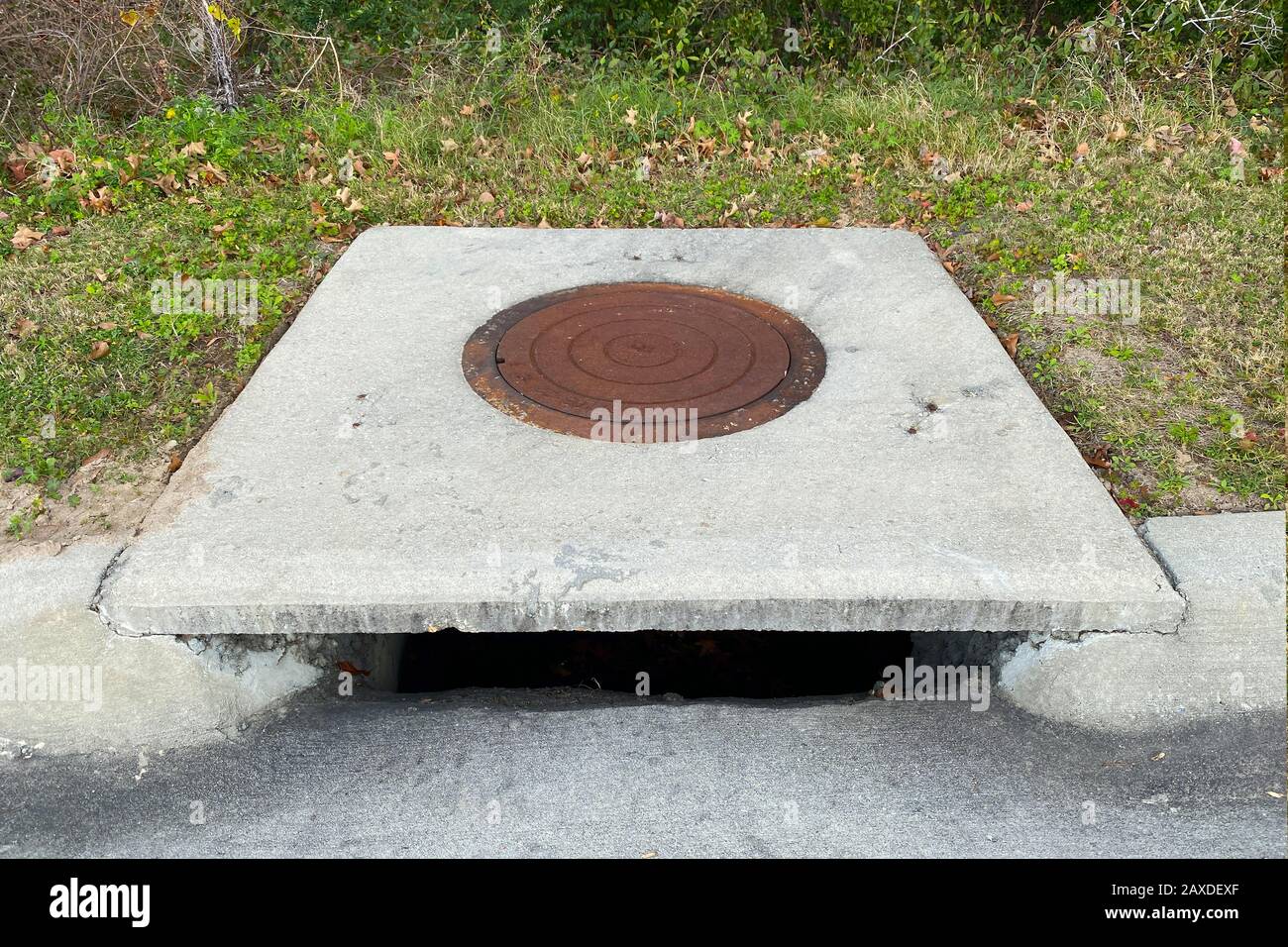 a city park street storm water drain and manhole cover Stock Photo - Alamy