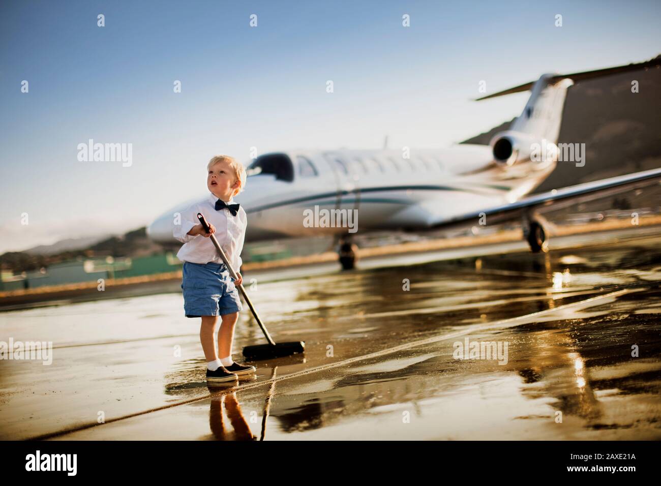 A young boy sweeping at the airport Stock Photo - Alamy