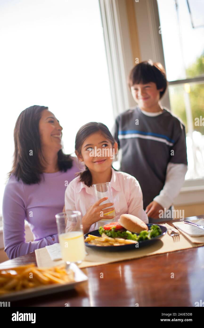 Happy family having fun eating at a dining table Stock Photo - Alamy