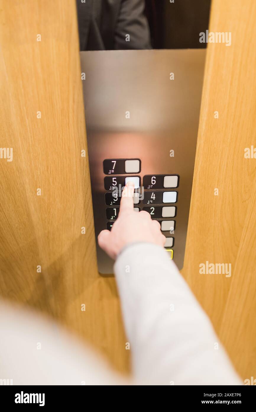 Close up of businessman pressing button in modern elevator Stock Photo ...