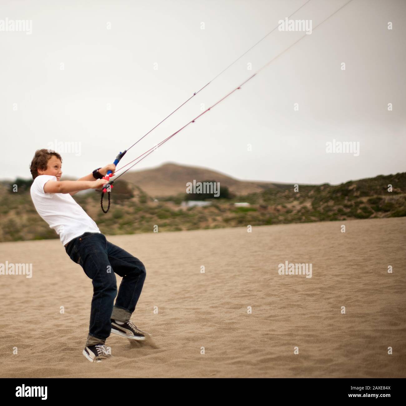 Boy looks up and pulls down hard on the handle of a two-string stunt ...