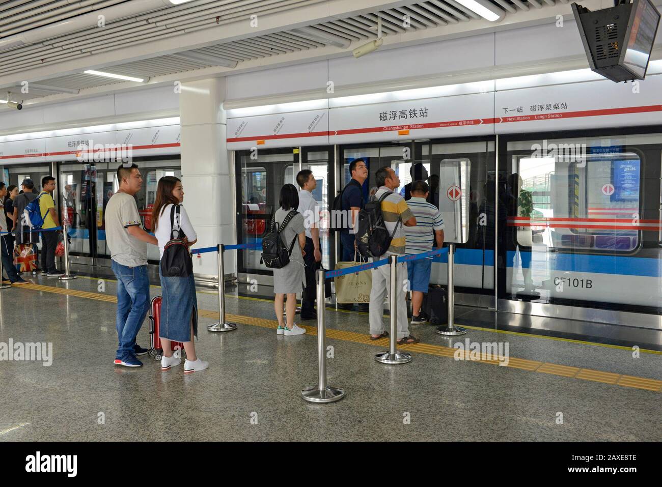 Passengers wait to board a train at the maglev station at Changsha high ...