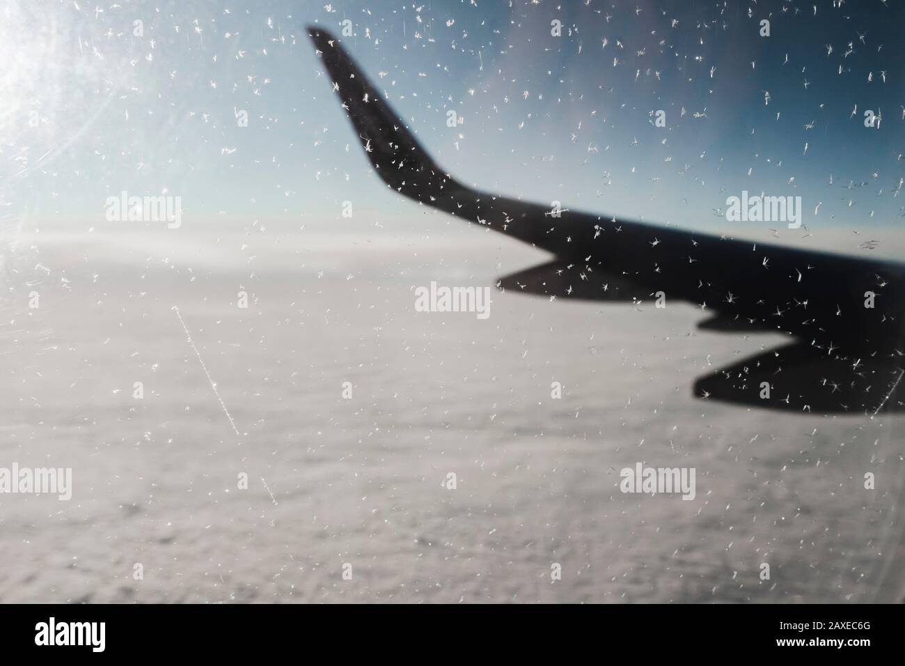 View of the morning winter sky through a frozen window of an airplane ...