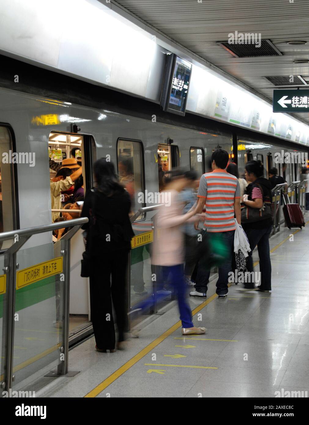 Passengers board and alight from a Shanghai metro line 2 train at a ...