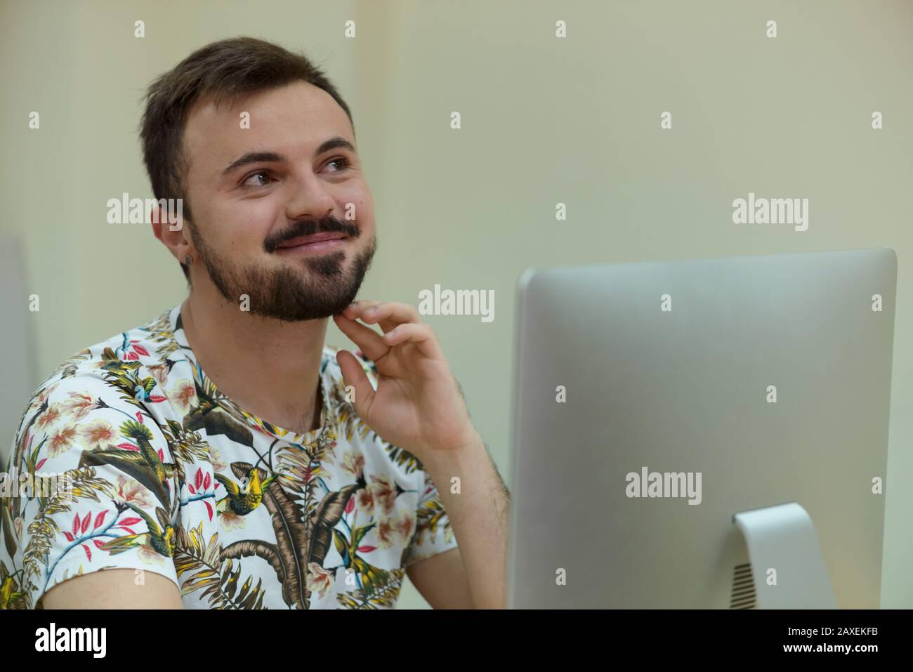 Male IT student working at his computer lab. Male student listening ...