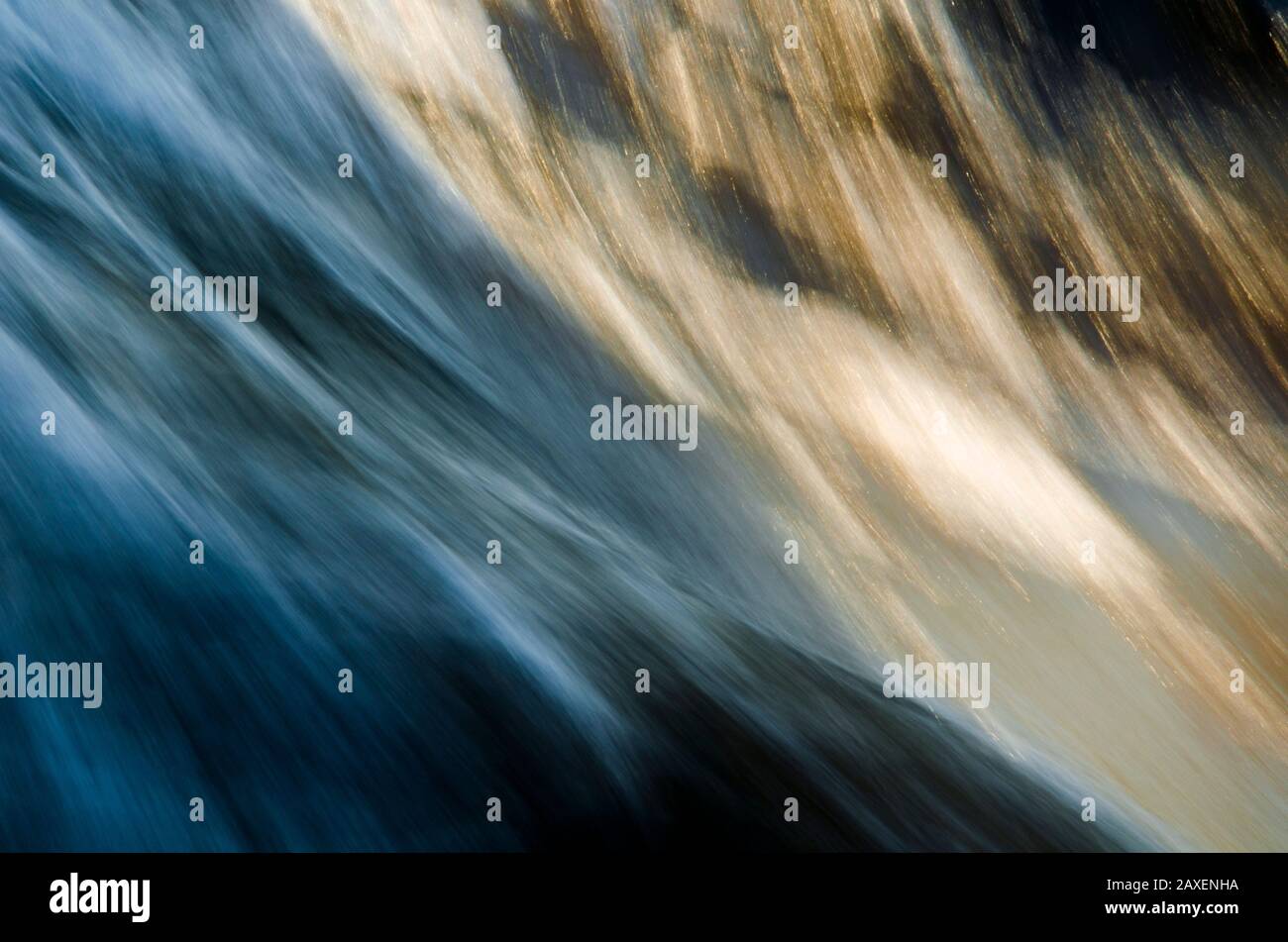 Texture of fast moving water, in blue, grey and yellowish soft tones ...