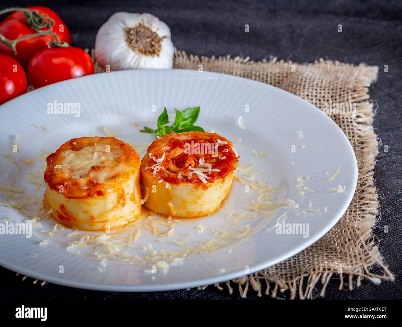 Italian rondelli with pomodoro sauce and cheese on rustic background ...