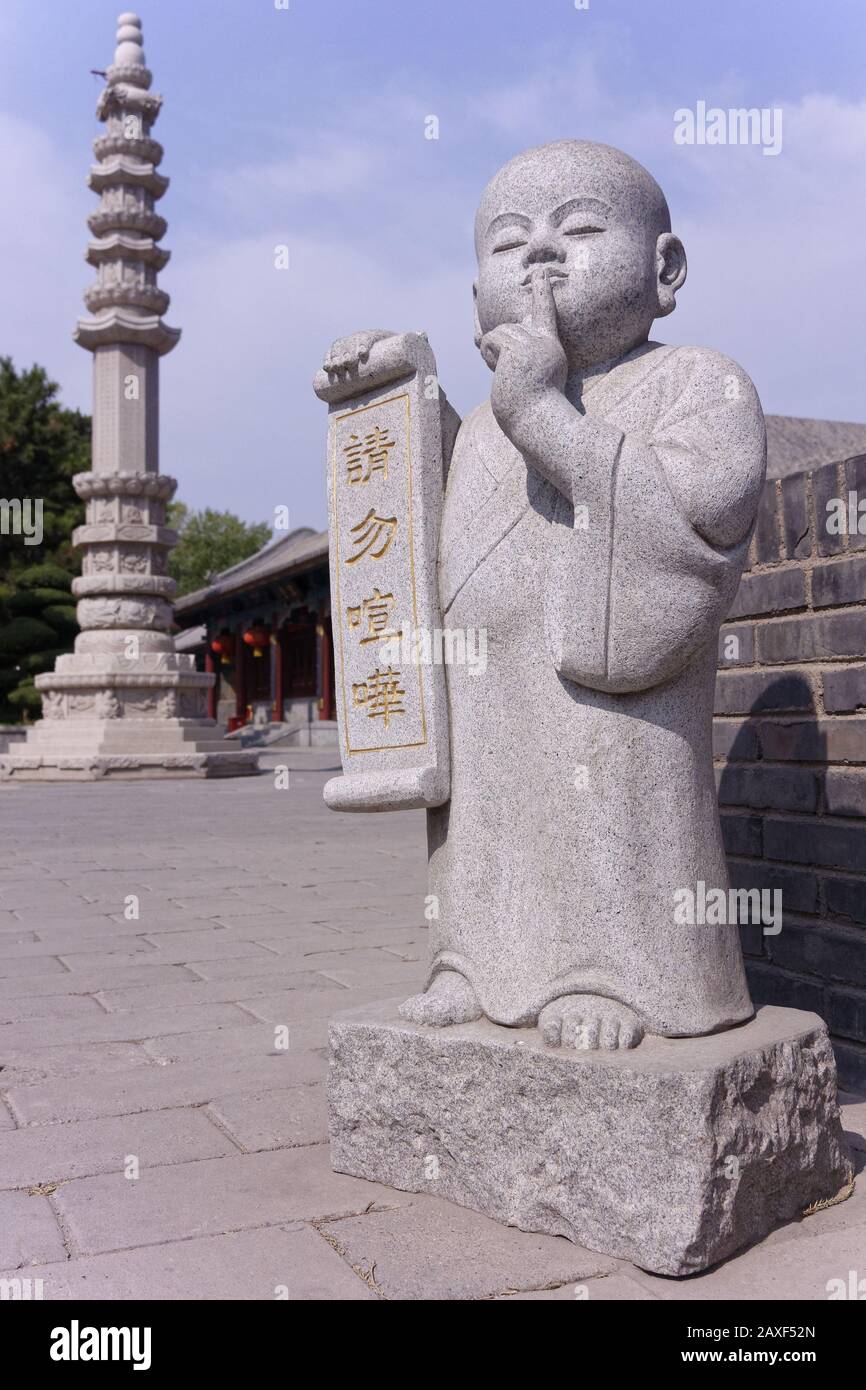 Vertical shot of an Asian statue holding a script of hieroglyphs Stock ...