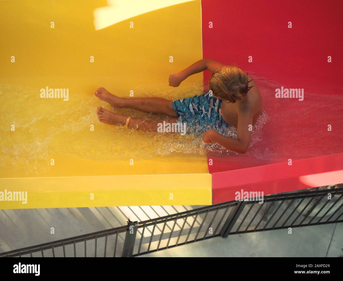 High angle view of a woman sliding on a colorful water slide under the ...
