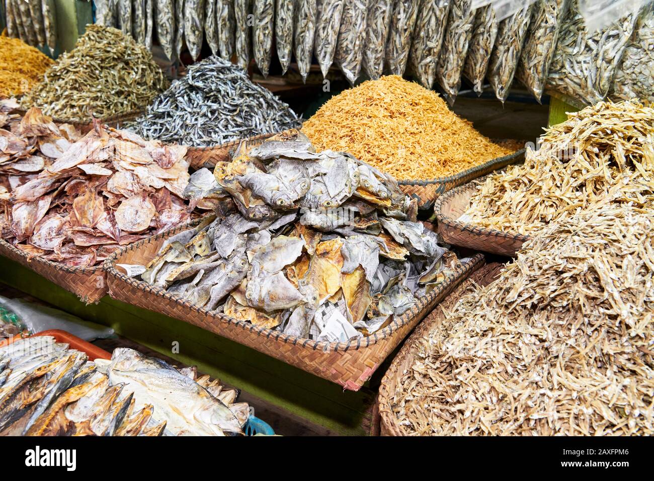 Close-up of heaps of dried and salted small fishes in bamboo baskets at ...