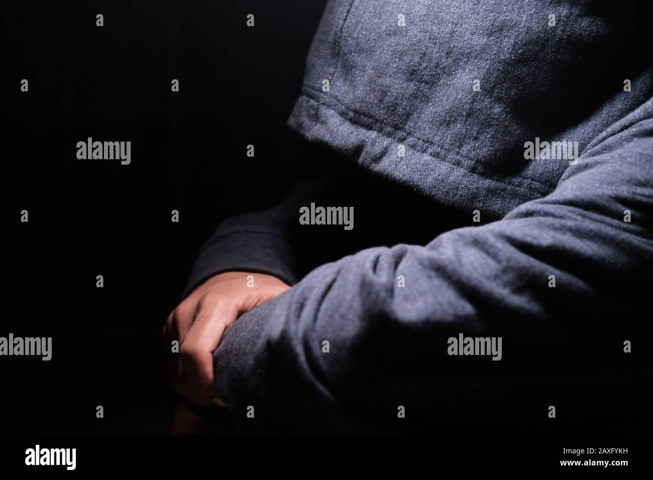 sad man with hood looking down at night Stock Photo - Alamy