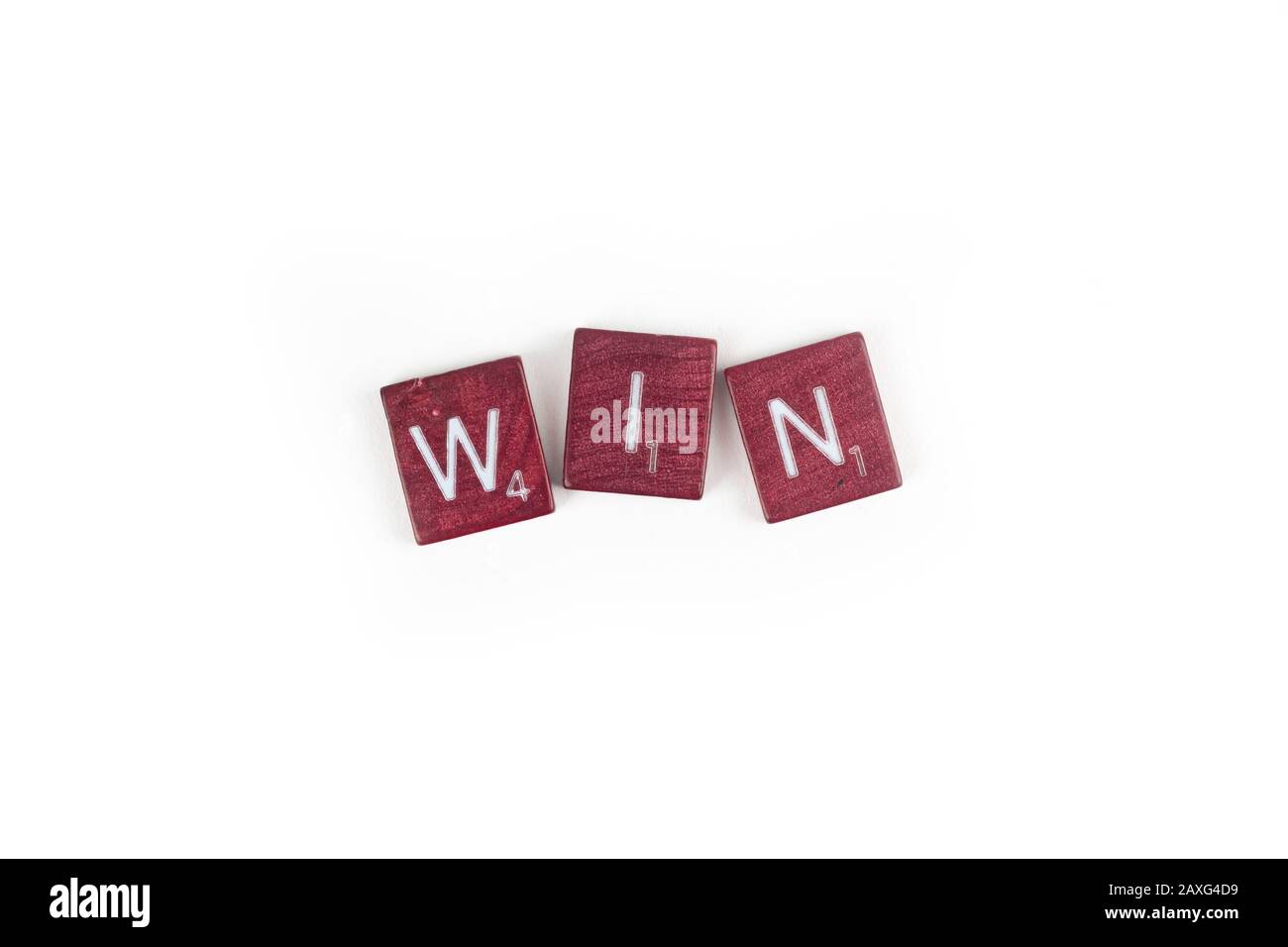 The word win spelled out in an uneven arrangement of game letter tiles ...