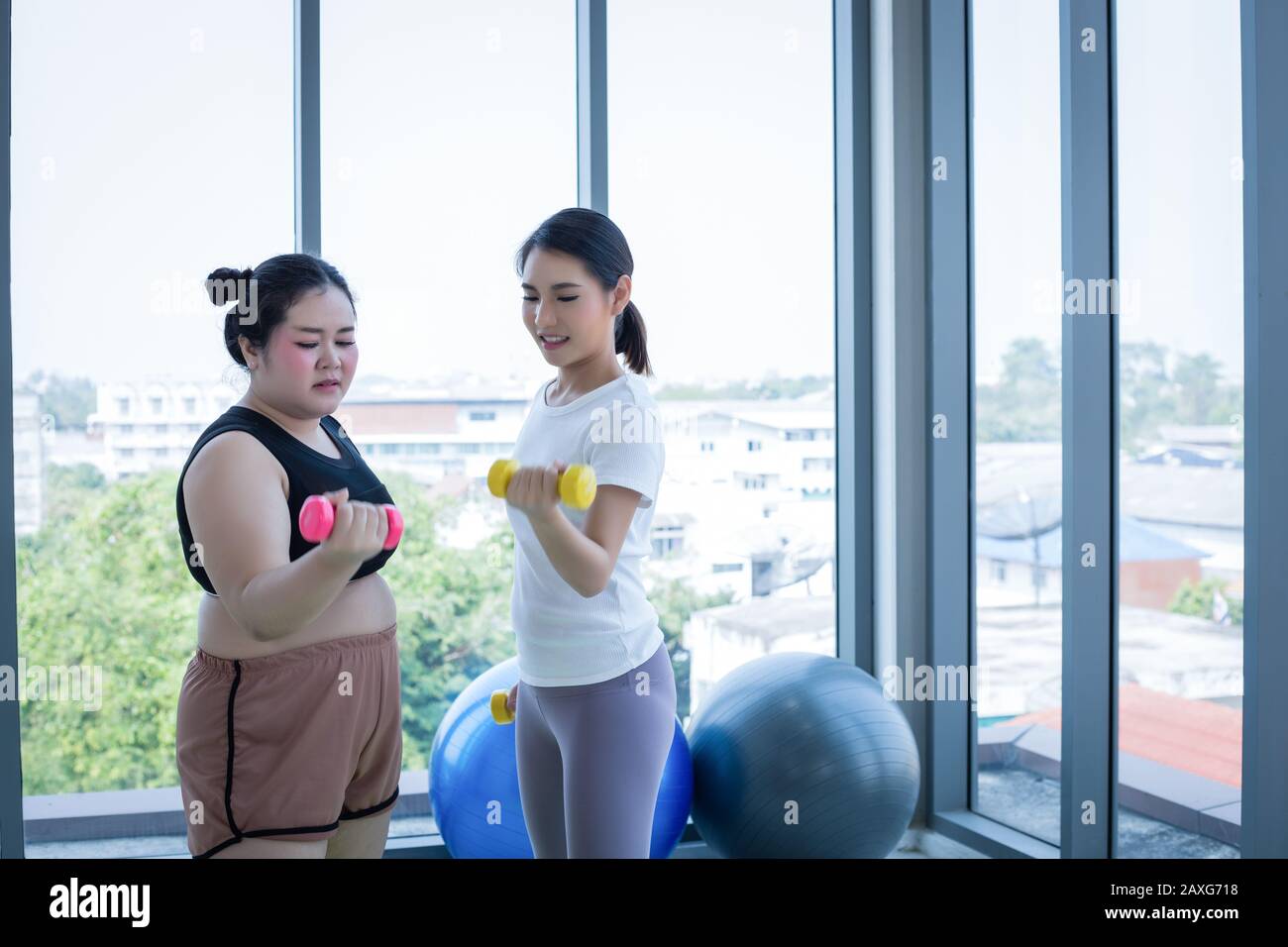 Asian Fat woman and trainer work out in the fitness class and The ...