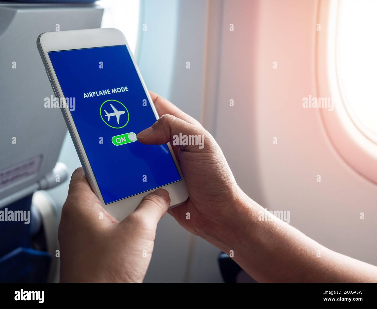 Flight mode concept. Hand holding white smartphone and turned on ...
