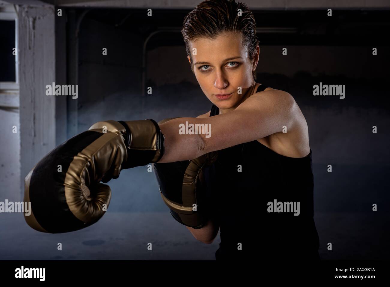 Closeup picture of beautiful female boxer practicing her punches with ...