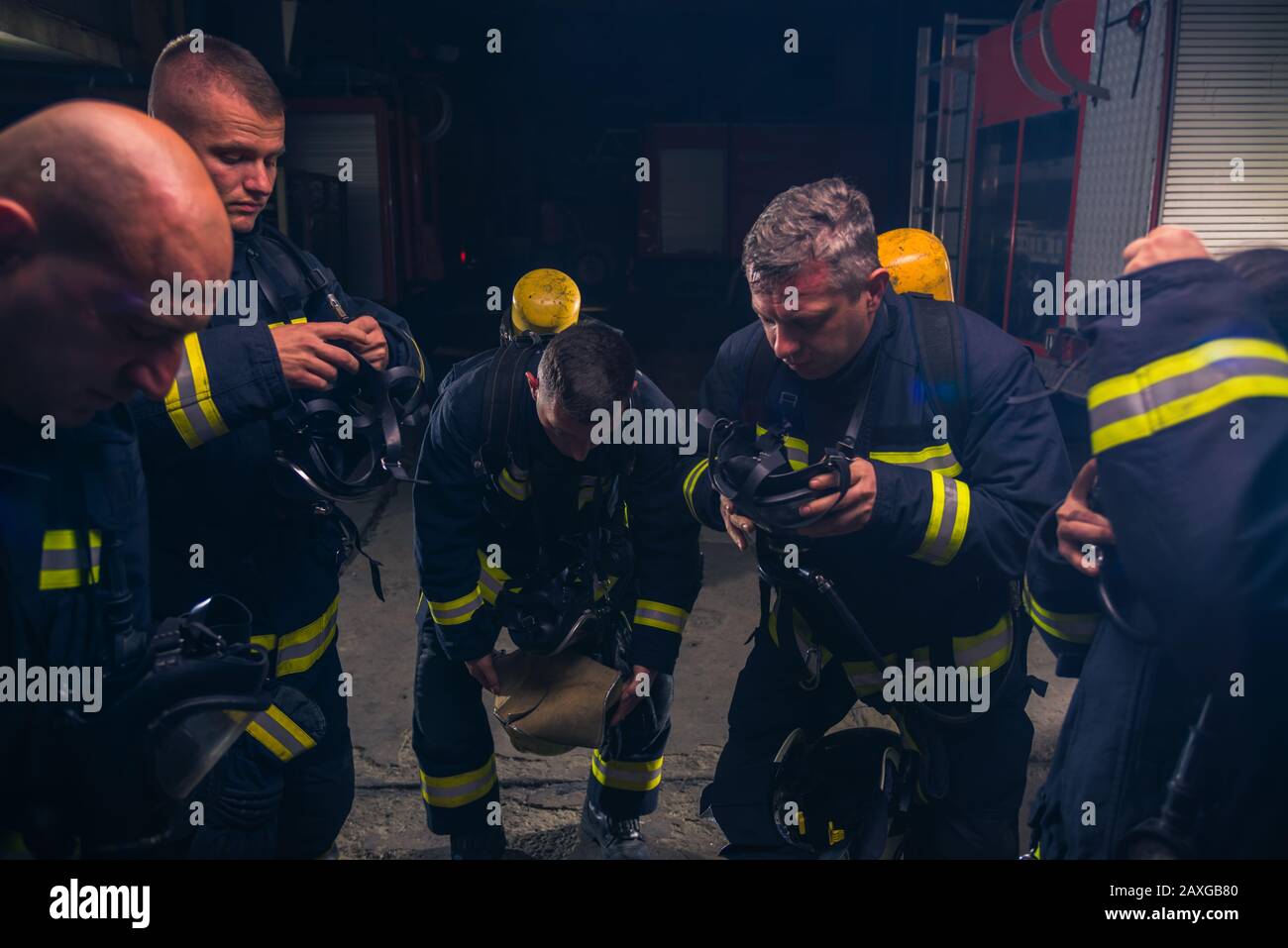 Group of firefighters standing inside the fire brigade wearing helmet ...