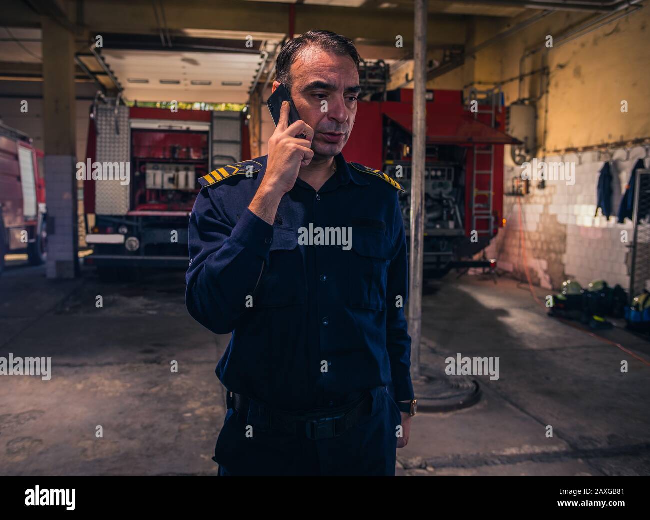 Portrait of fireman talking on the phone while standing inside the fire ...