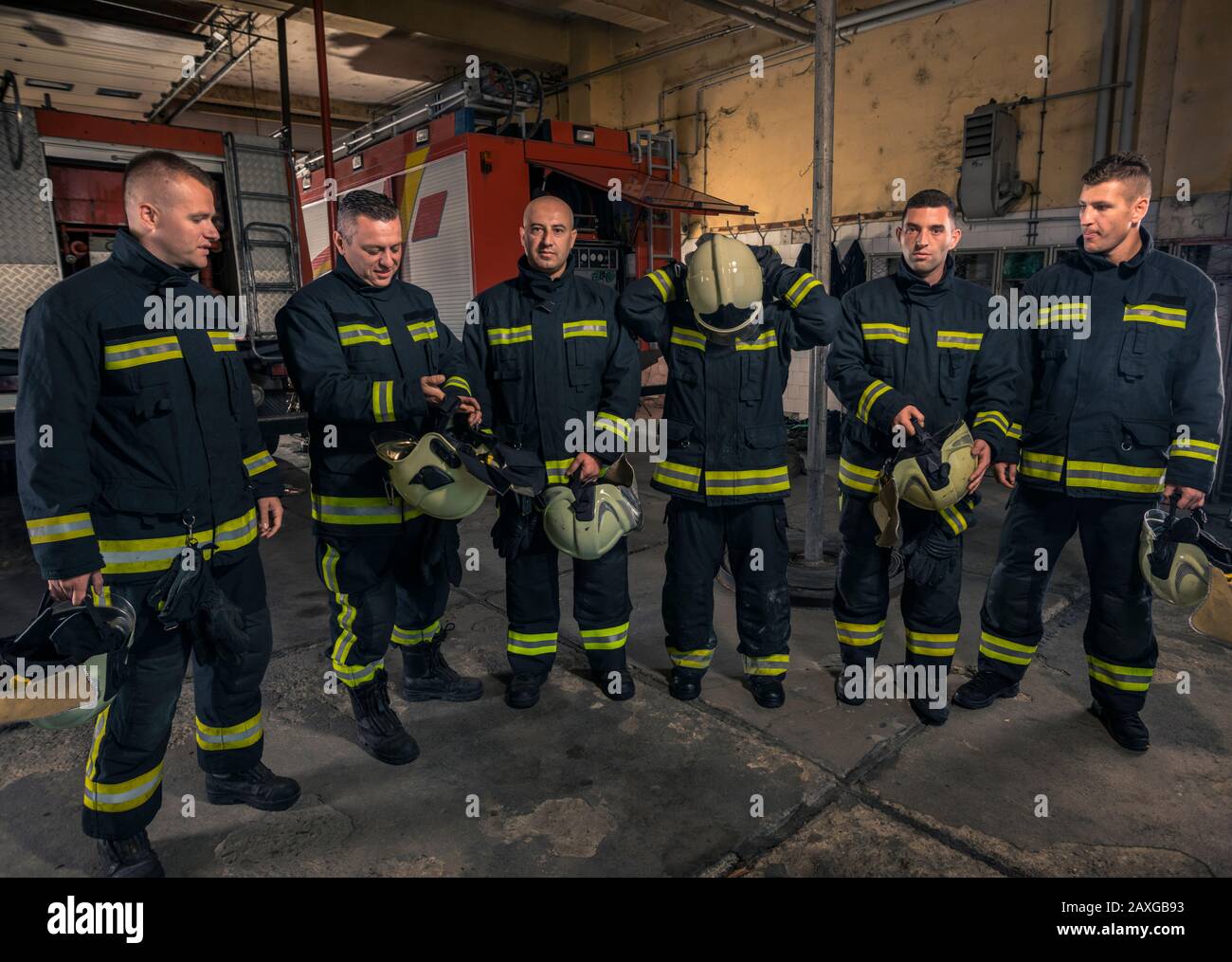 Portrait of firefighters standing by a fire engine Stock Photo - Alamy