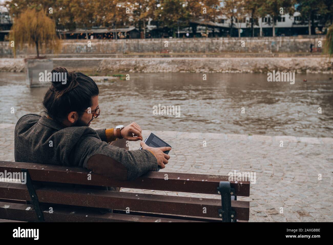 Modern day hipster reading a book outdoors at the river promenade Stock ...