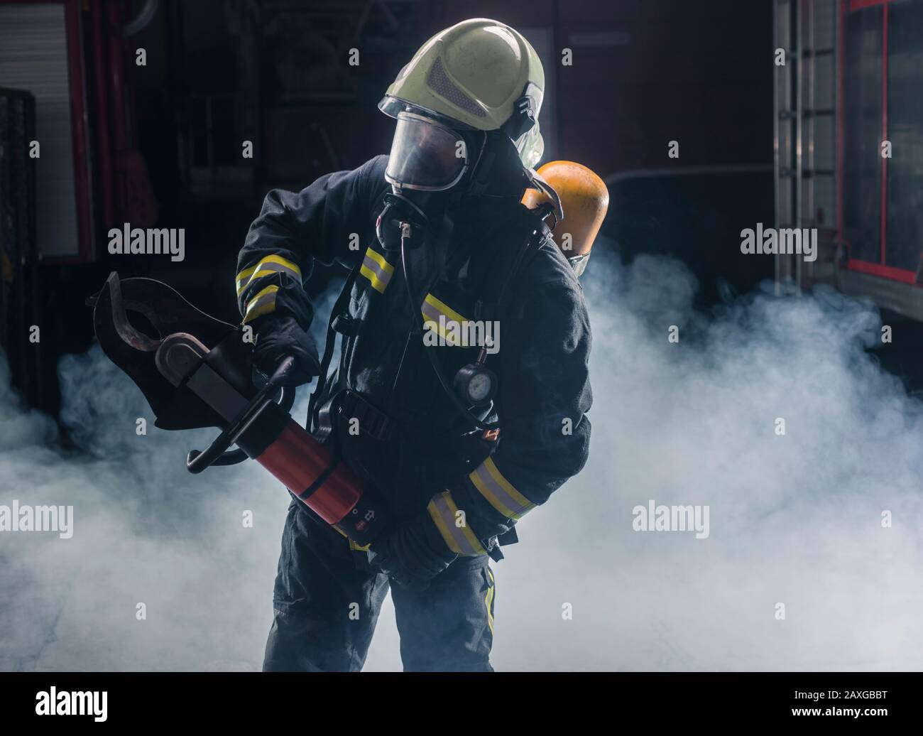Portrait of a fireman wearing firefighter turnouts and helmet. Dark ...