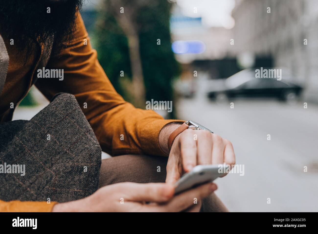 Modern hipster young guy checking his mobile phone at the city square ...