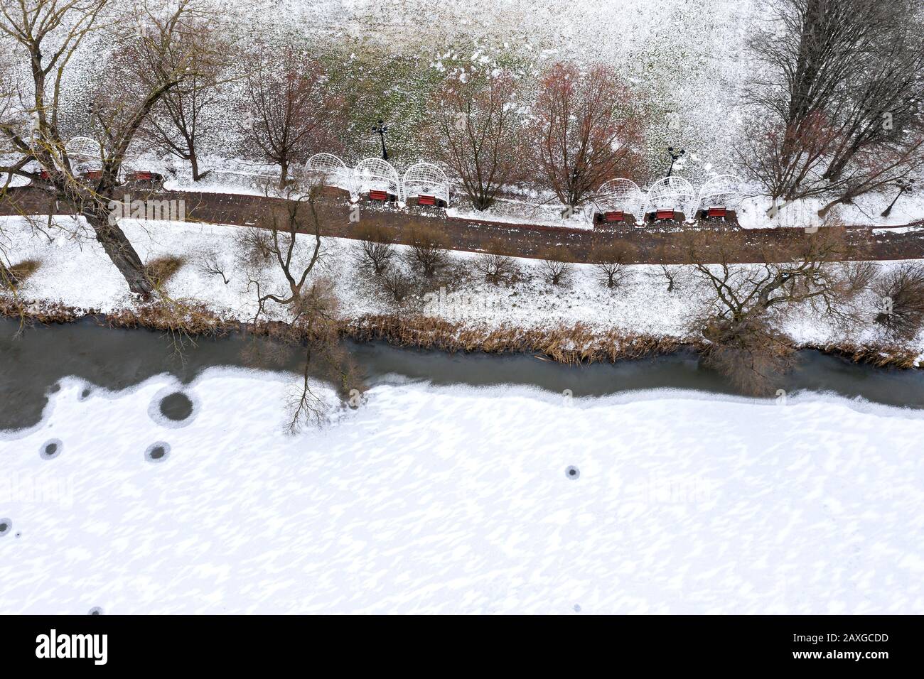 snowy winter park landscape with ice-covered river, footpath and frozen ...