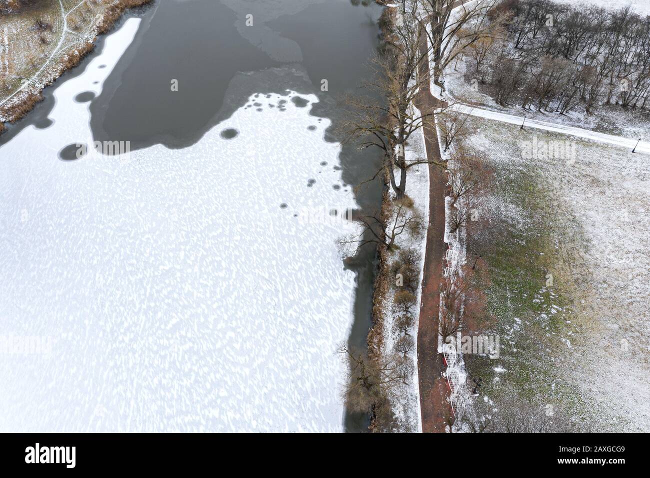 aerial view of the snowy river and footpath on riverbank in winter city ...