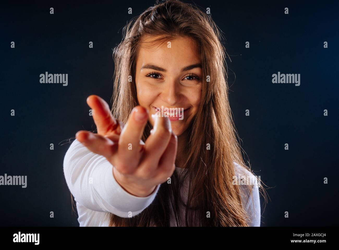 Handsome female model pointing at you while standing in front of a ...