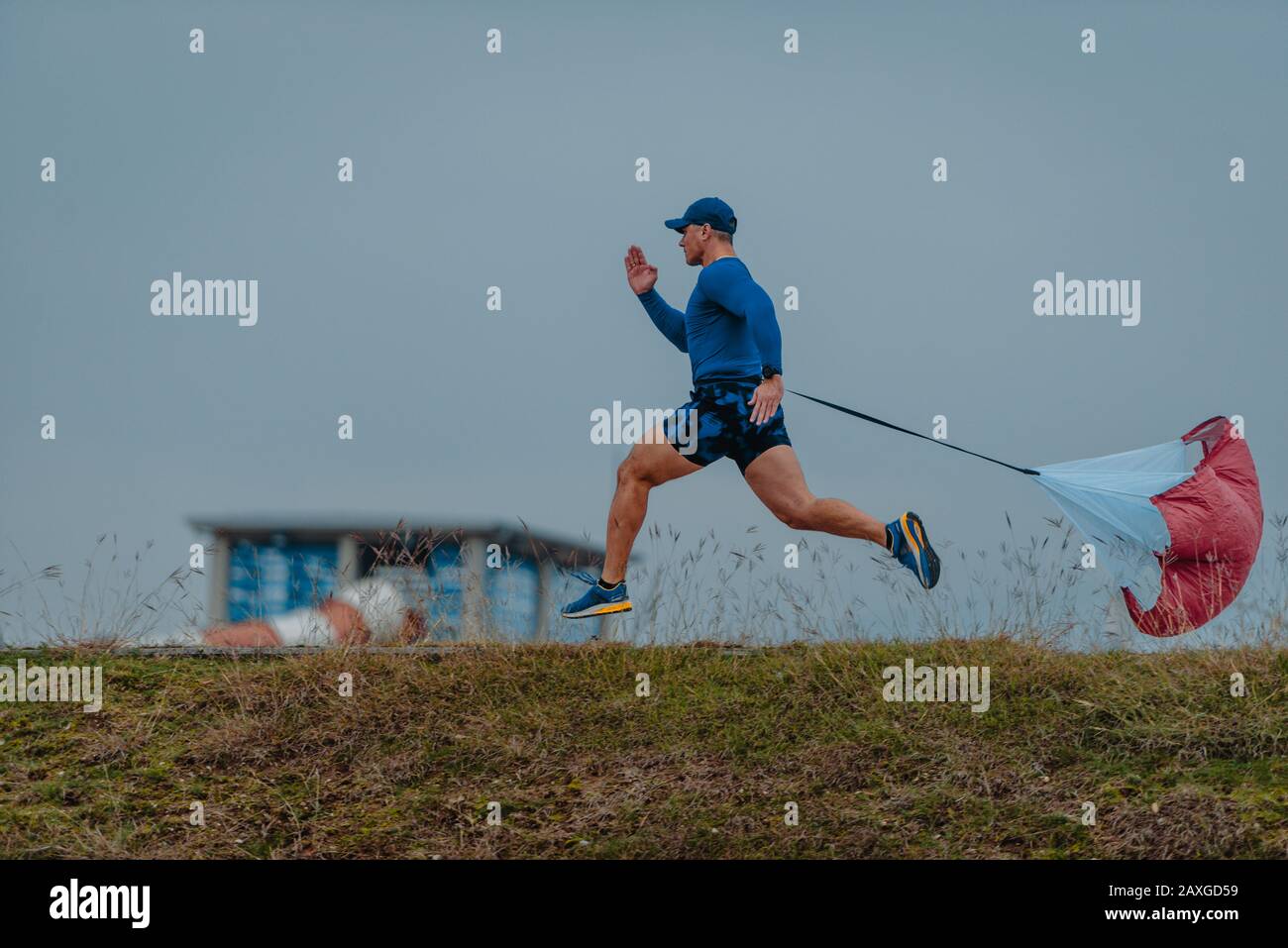 Muscular older runner dressed in fitness wear sprinting outdoors with a ...