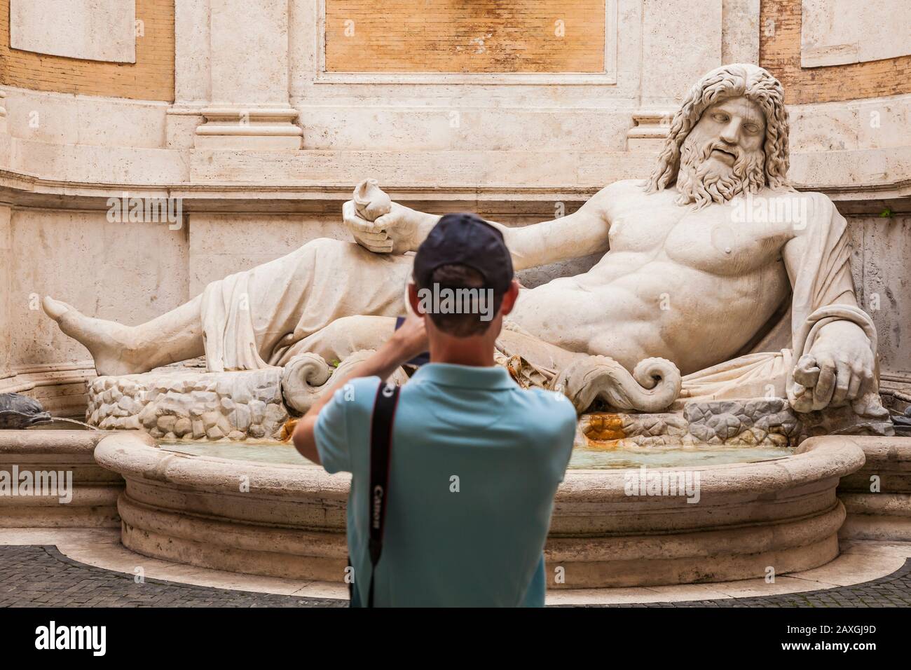 A tourist takes apicture of a fountain featuring Marforio, River God ...