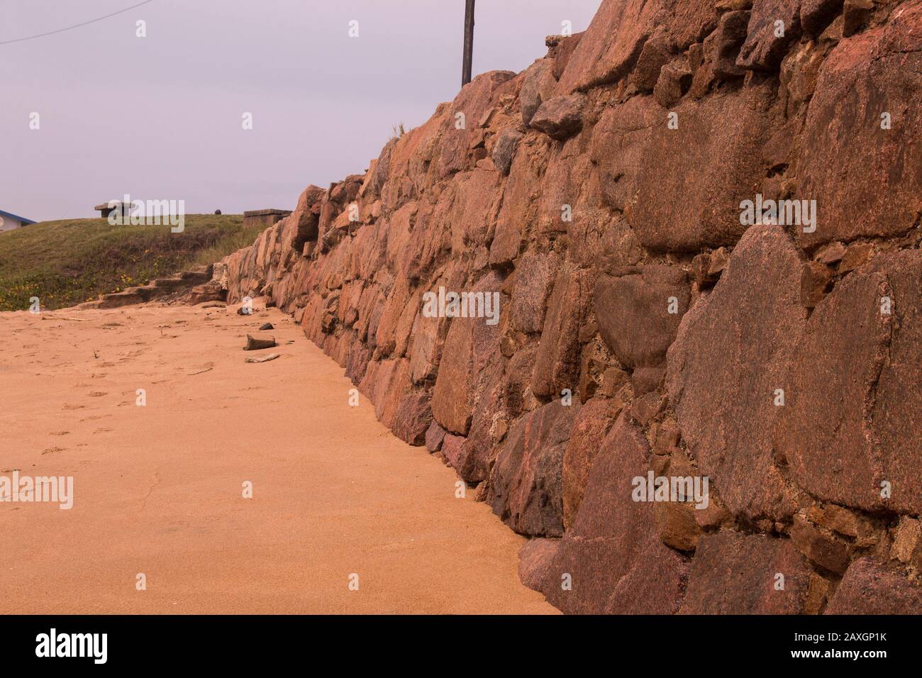 Constructed retaining stone wall lining edge of beach sand Stock Photo ...