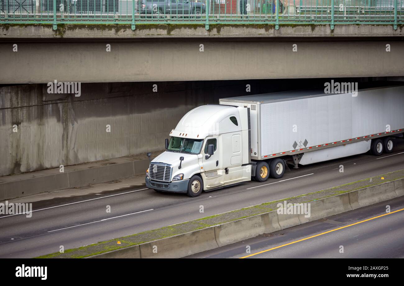 Big rig long haul white semi truck with low cab and spoiler for improve ...