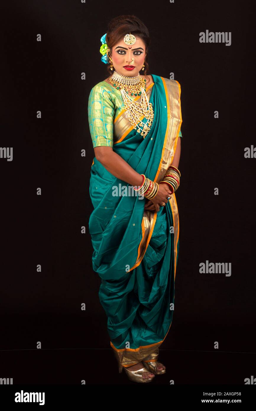 Studio shot of Indian woman in traditional green sari and jewelry ...