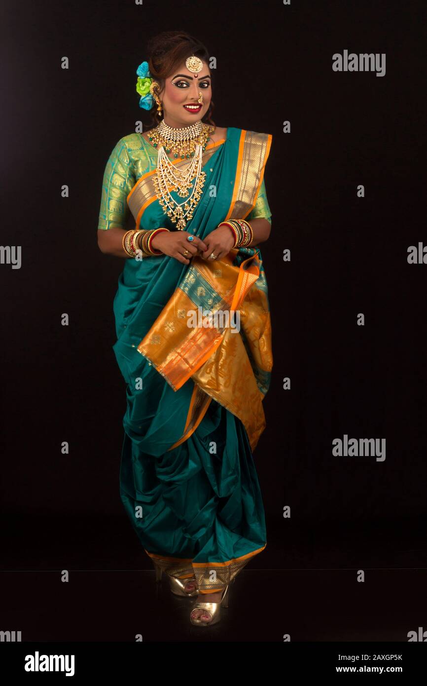 Studio shot of Indian woman in traditional green sari and jewelry ...