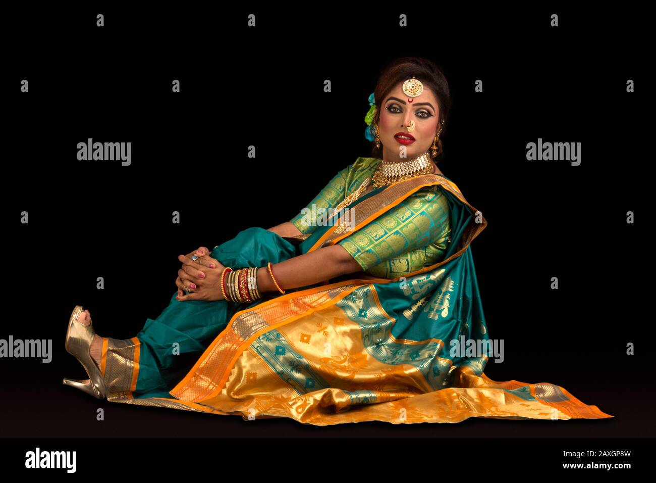 Studio shot of Indian woman in traditional green sari and jewelry ...