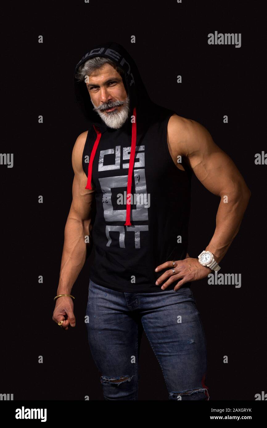 Portrait of stylish old man with gray beard and sports wear, looking at ...