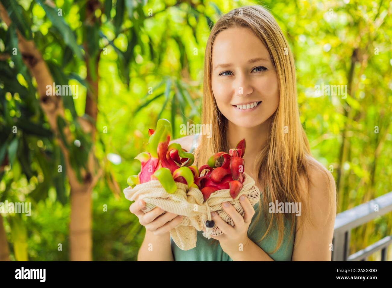 Dragon fruit in a reusable bag in female hands. Zero waste concept ...