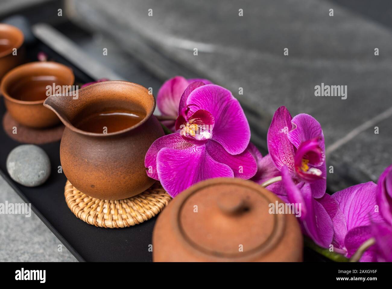 Traditional Chinese tea Set up with orchid and pebbles Stock Photo - Alamy