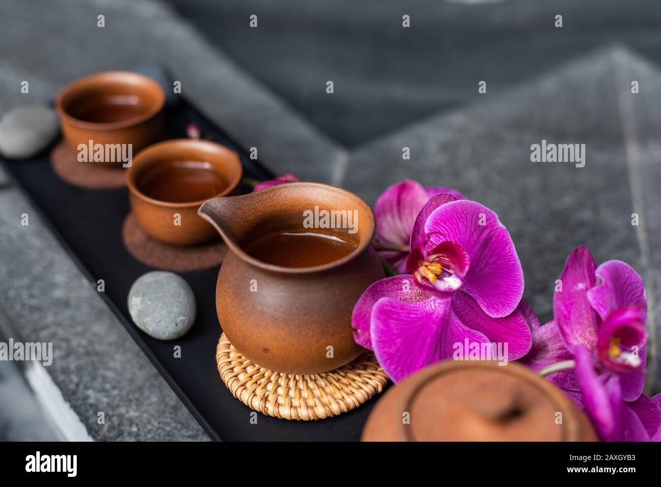 Traditional Chinese tea Set up with orchid and pebbles Stock Photo - Alamy