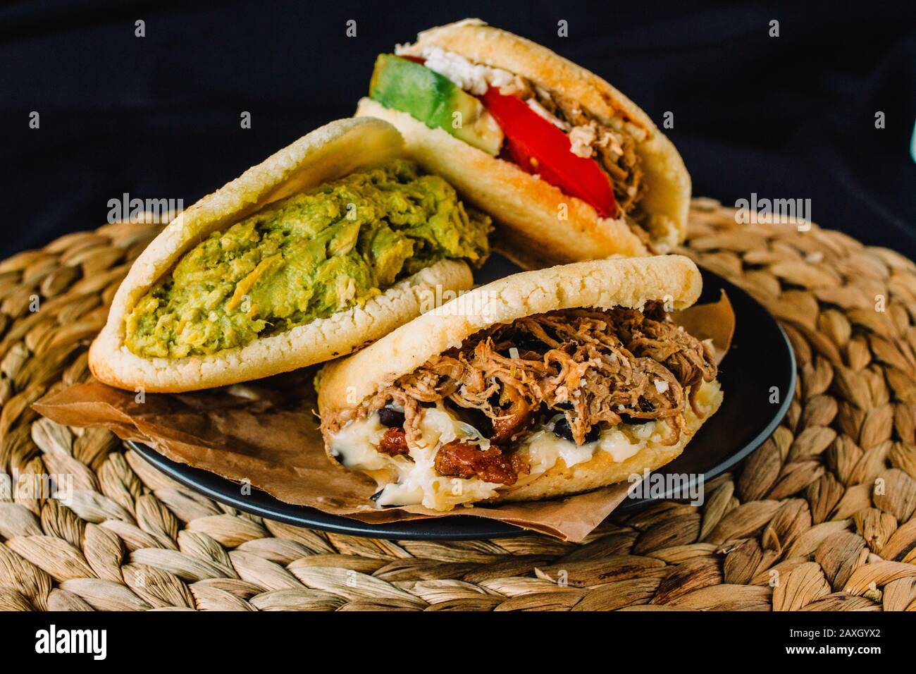 Venezuelan arepas on a black background, made with maize and filled ...