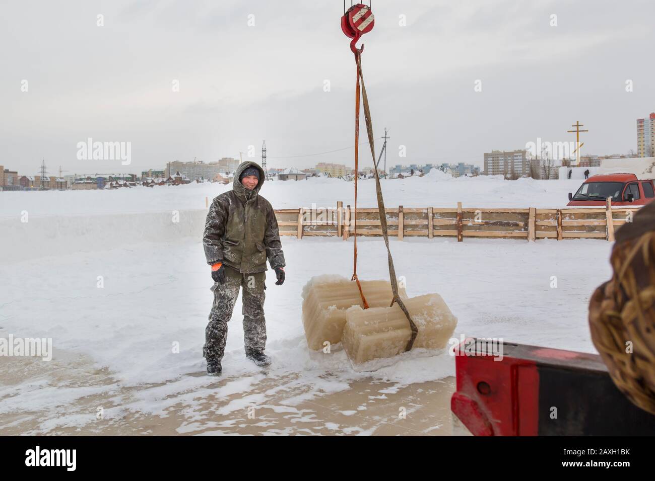 Slinger works with a truck crane on ice Stock Photo - Alamy