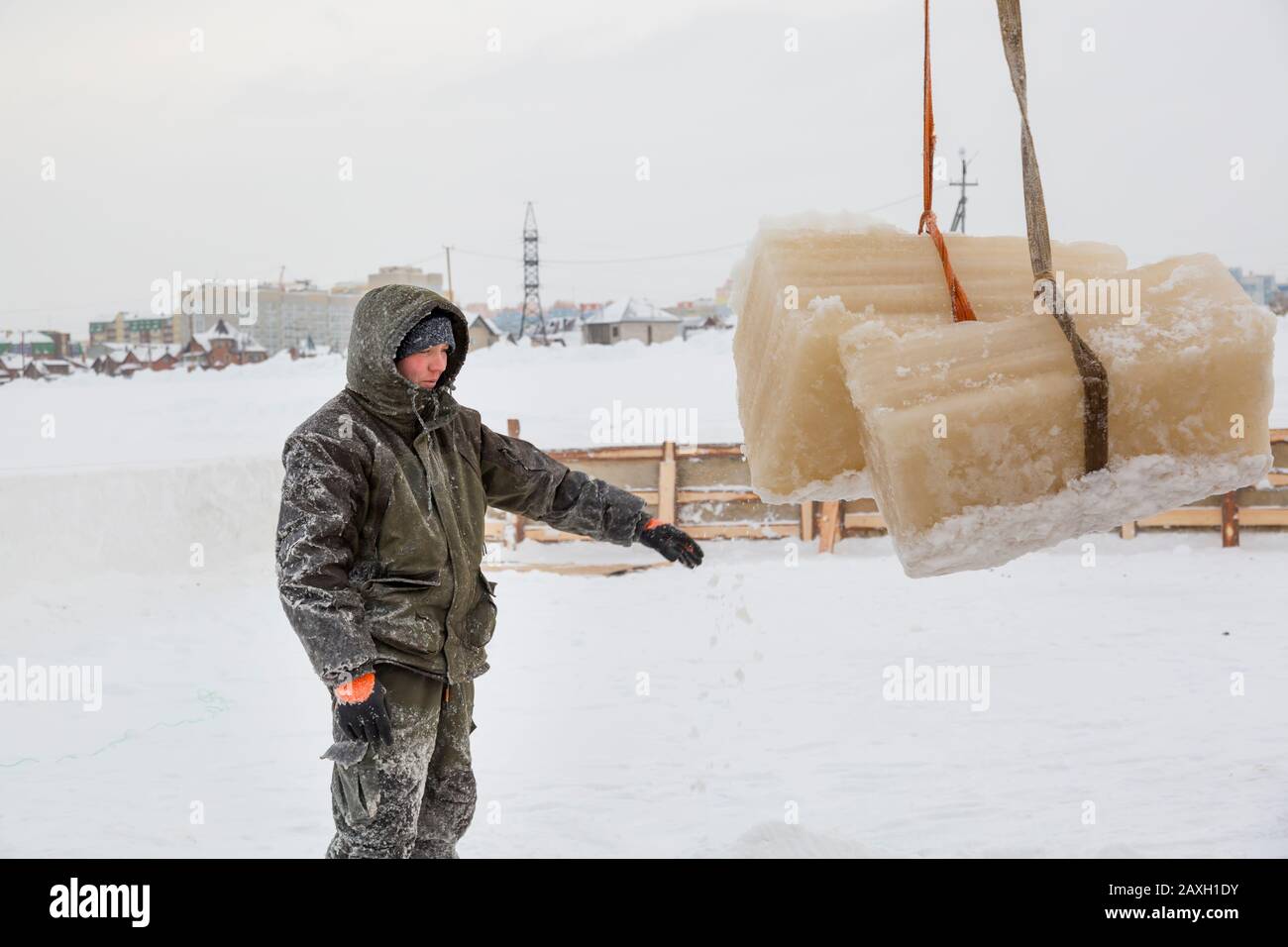 Slinger works with a truck crane on ice Stock Photo - Alamy