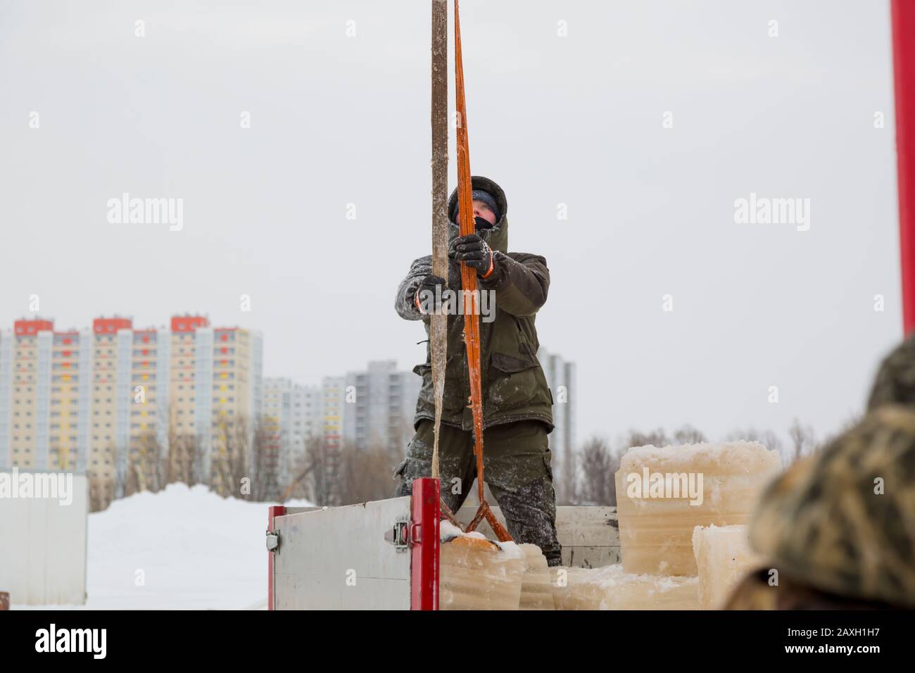 Slinger works with a truck crane on ice Stock Photo - Alamy