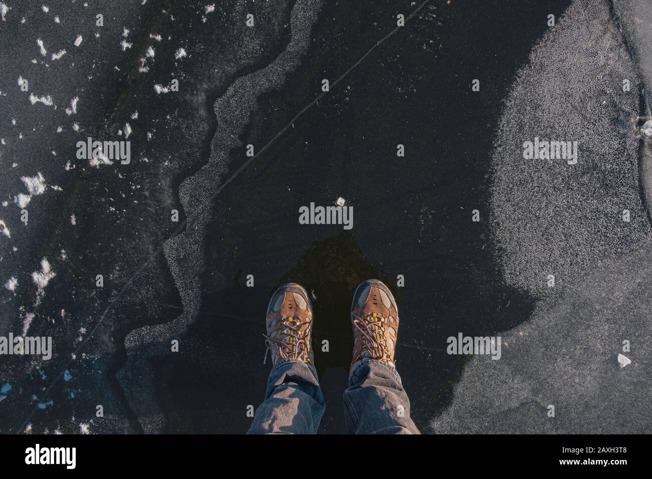 Standing on the thin ice, top view. Human feet on beautiful textured ...