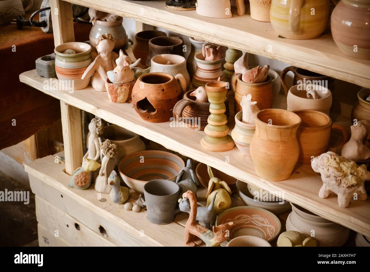Wooden racks in a pottery workshop in which there are pottery, many ...