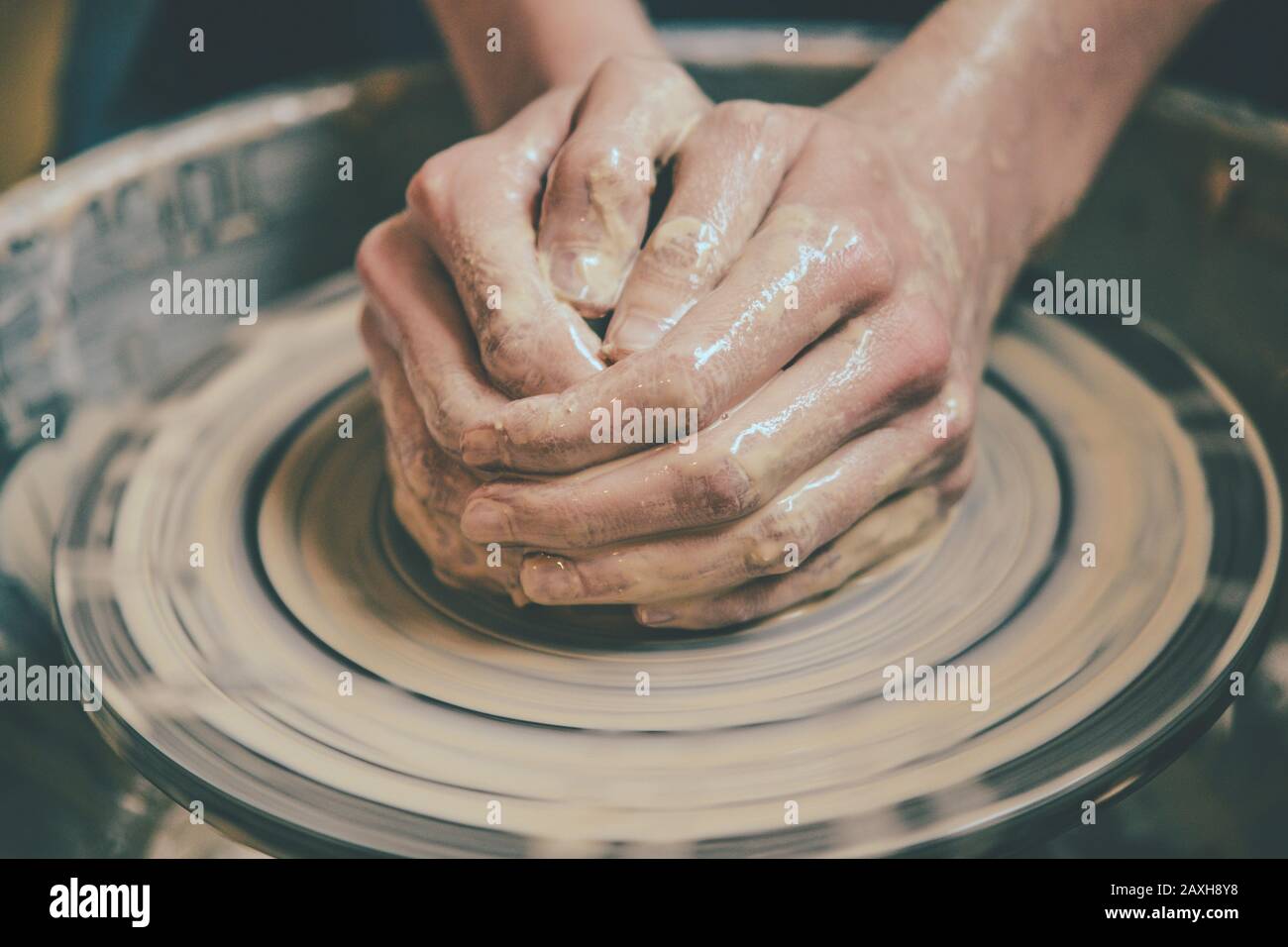 Master potter folded together hands sculpts a clay product on a potter ...