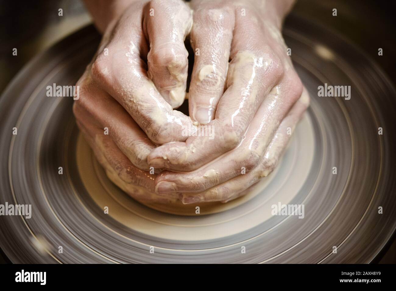 Master potter folded together hands sculpts a clay product on a potter ...