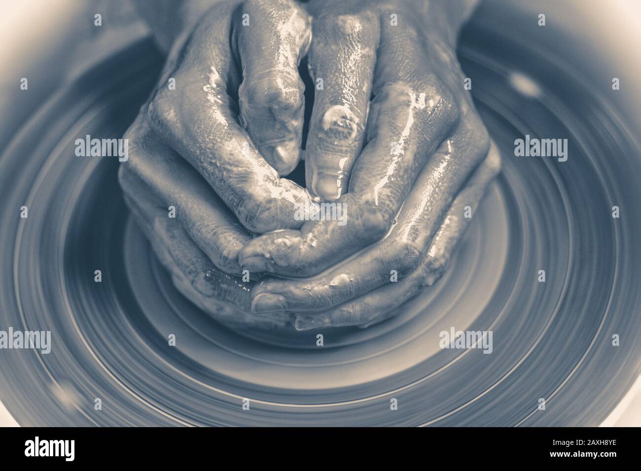 Old vintage photo. Master potter folded together hands sculpts a clay ...